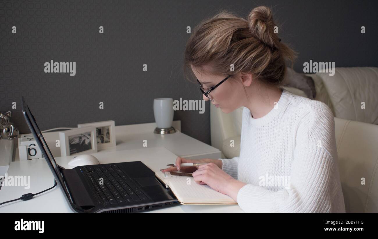 Young female freelancer works remotely. Setting up a workplace at home ...