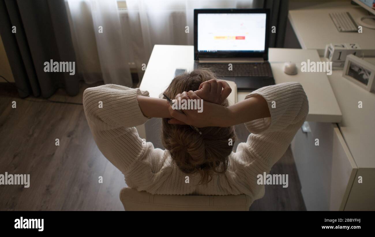 Take a break, a young woman in the workplace at the computer, stopped ...