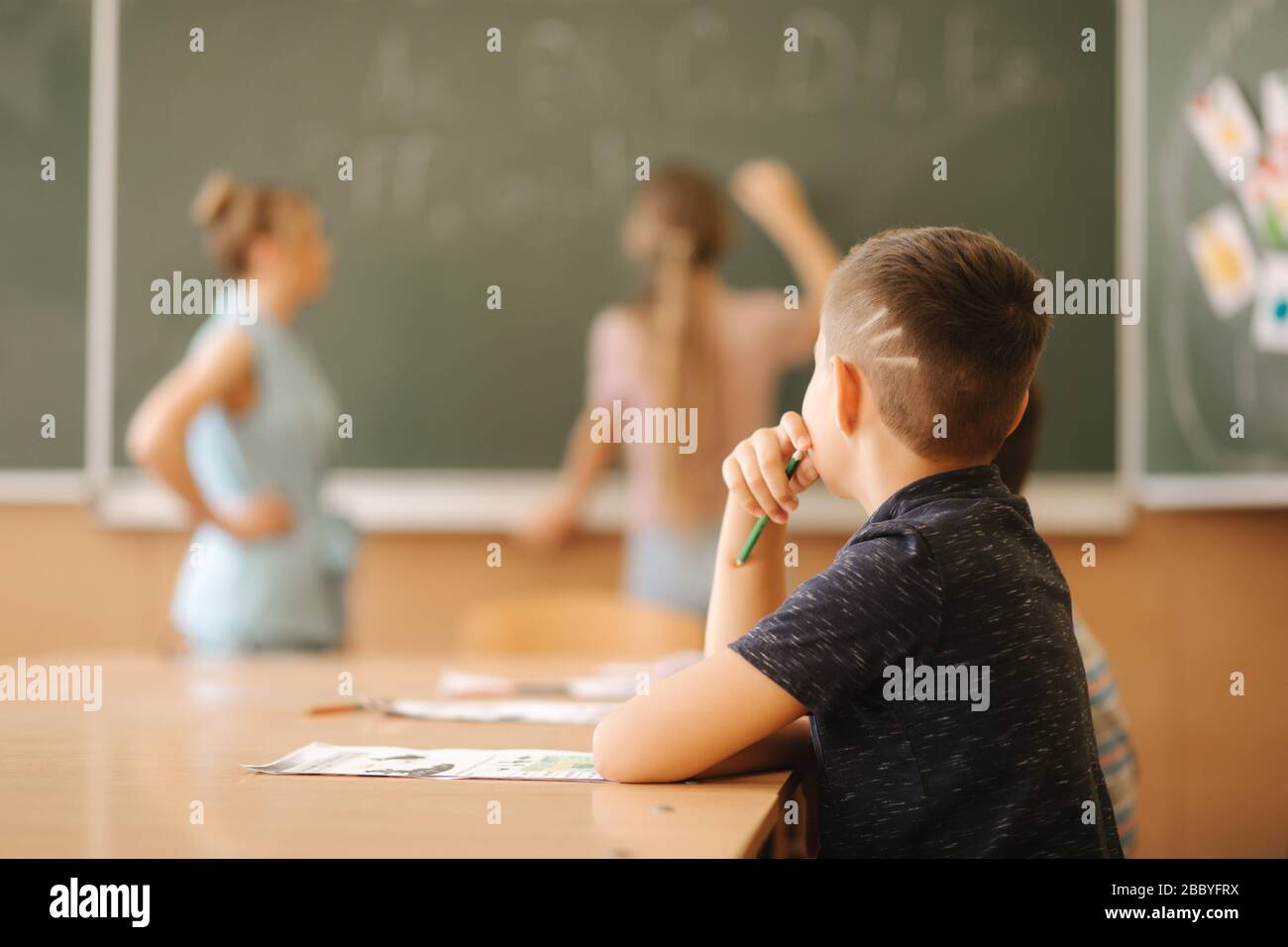 Schoolgirl writing something on blackboard in classroom Stock Photo - Alamy