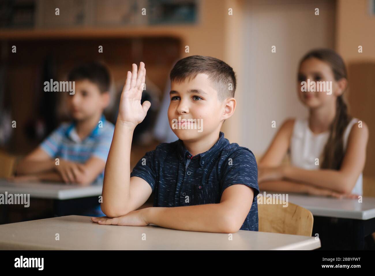 Kids raise their hand in class hi-res stock photography and images - Alamy