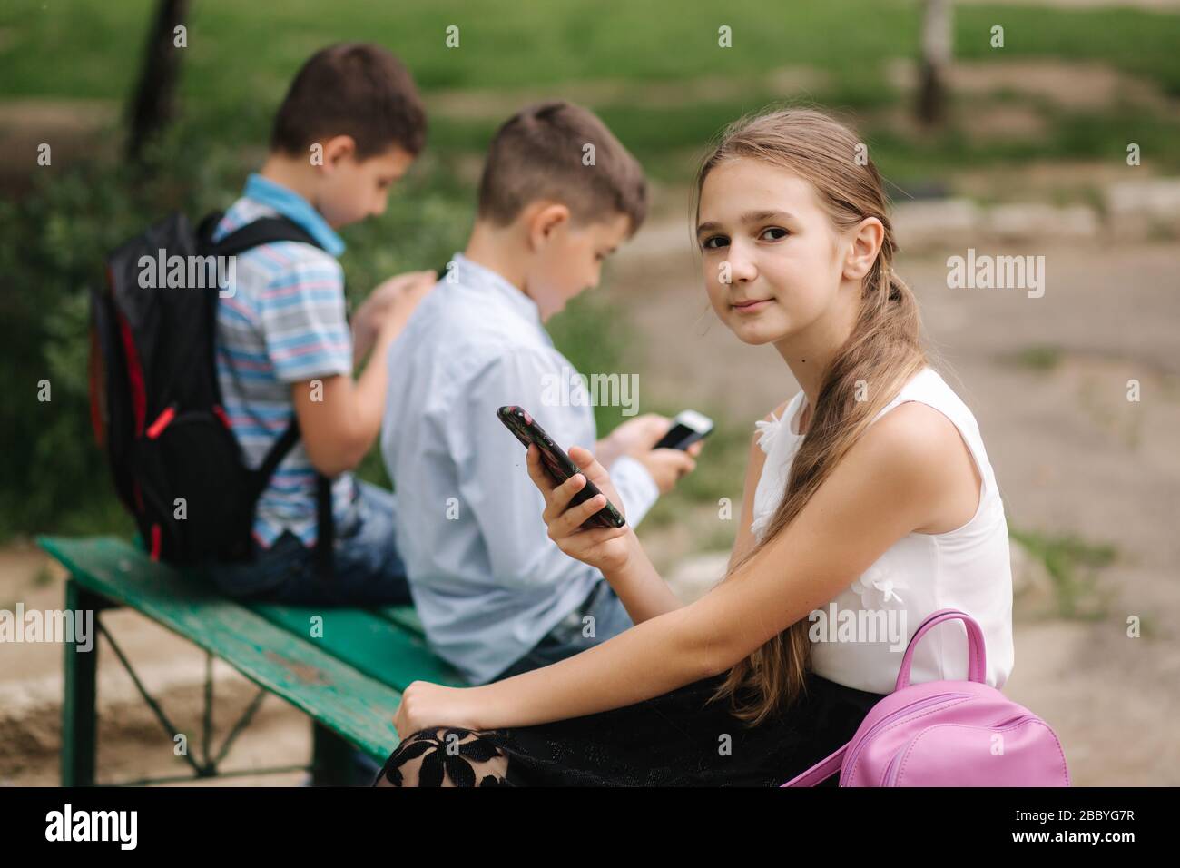 Two boys and girl use their phones during school breack. Cute boys ...