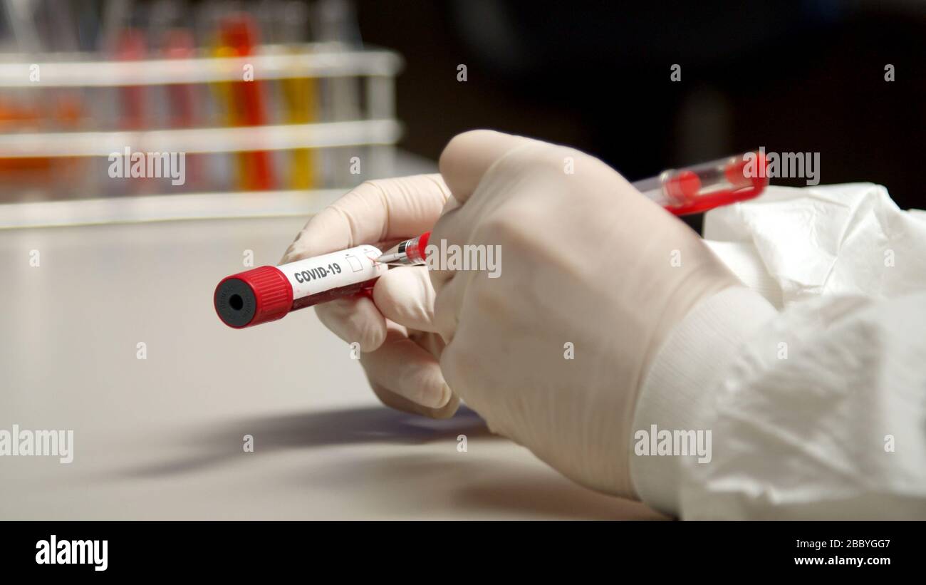 Scientist marking with pen COVID-19 test tube Stock Photo - Alamy