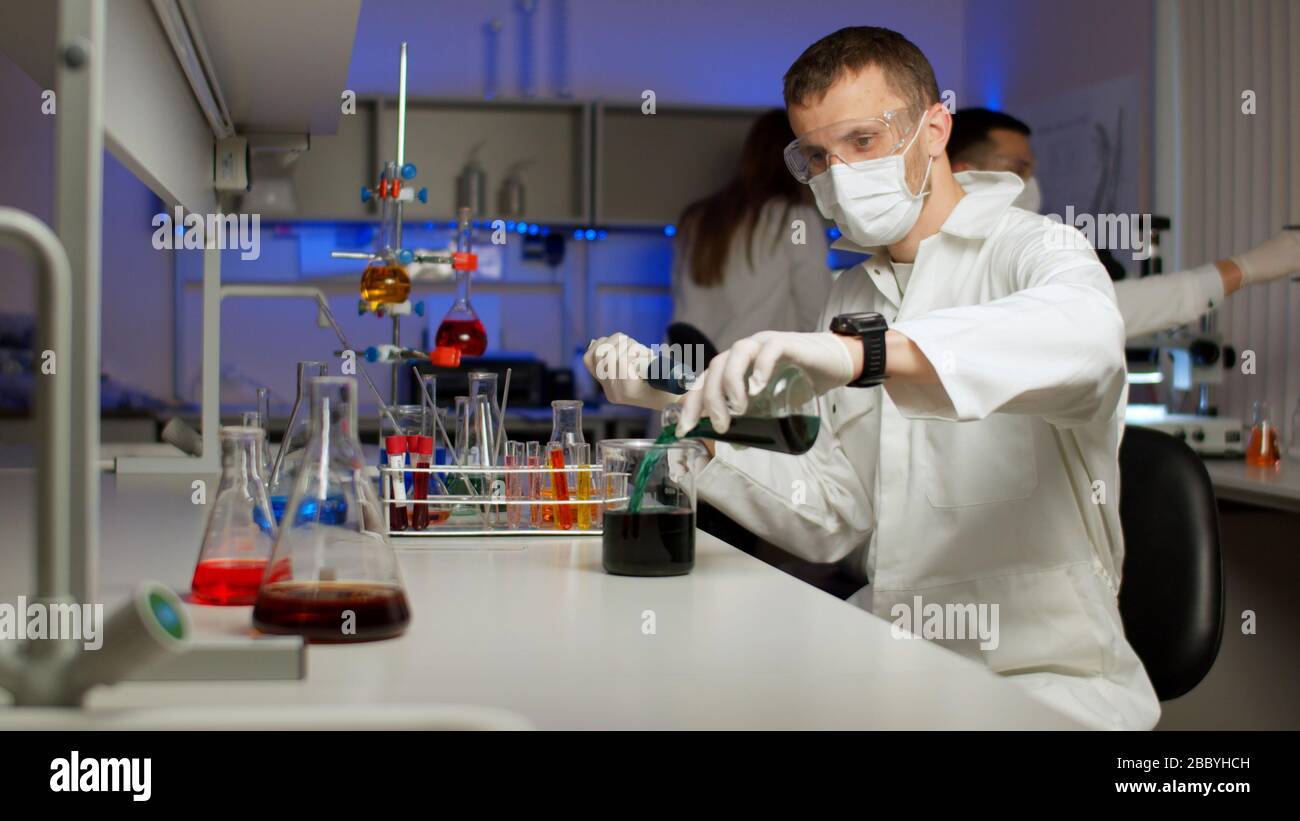 Young scientist mixing colored liquids in a flask Stock Photo - Alamy