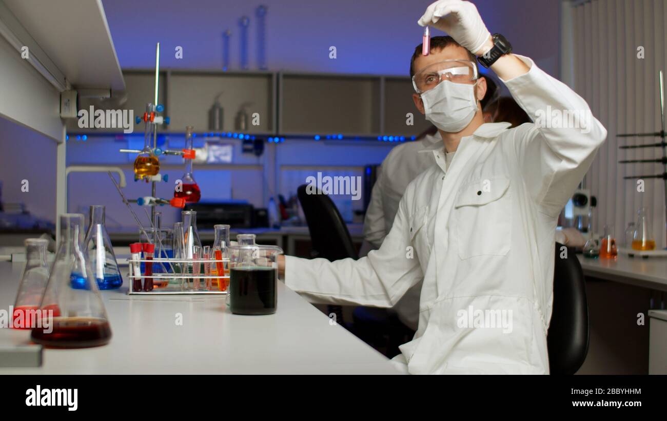 Young scientist mixing colored liquids in a flask Stock Photo - Alamy