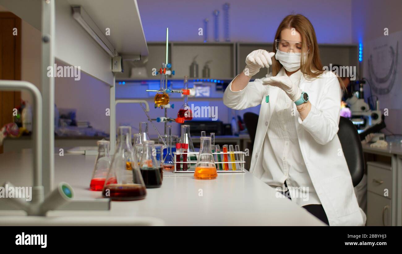 Young scientist mixing colored liquids in a flask Stock Photo - Alamy
