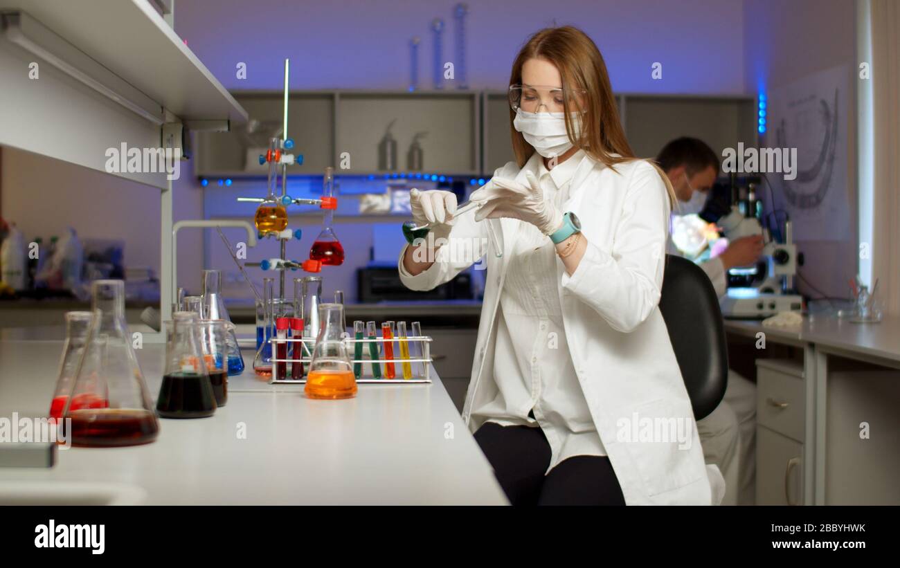 Young scientist mixing colored liquids in a flask Stock Photo - Alamy