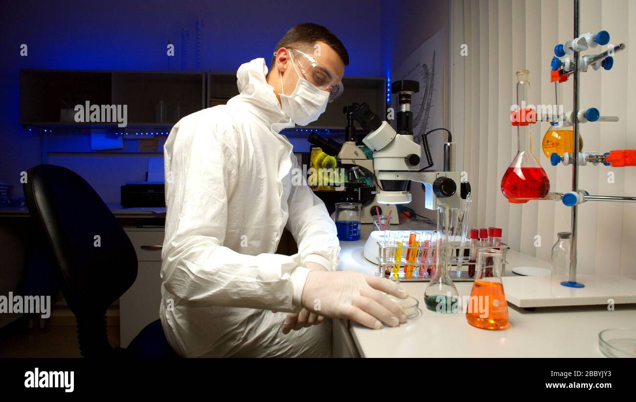 Young scientist examines virus samples with a microscope Stock Photo ...