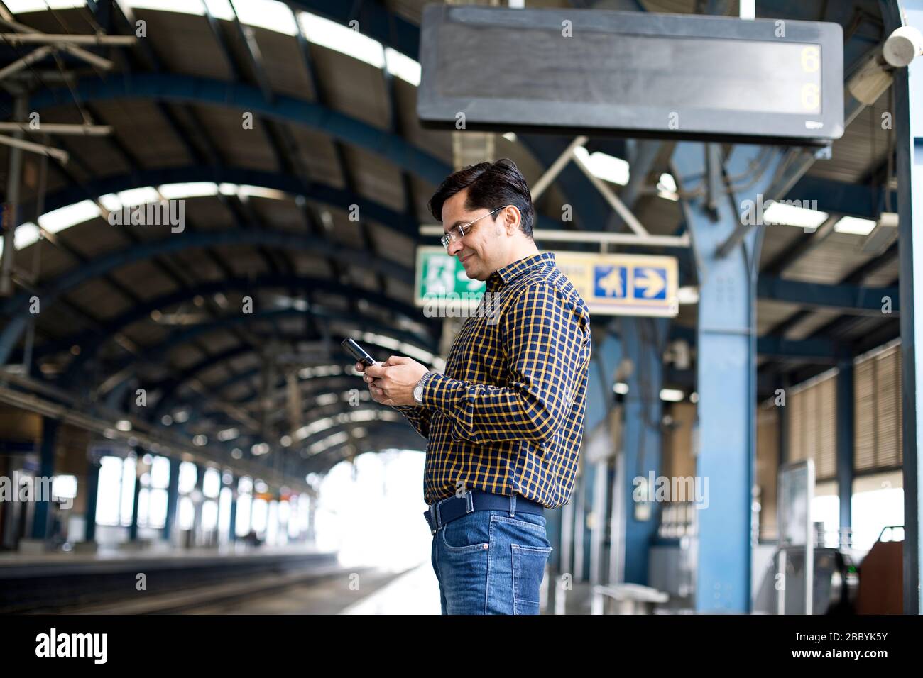 Man using mobile phone at railroad station platform Stock Photo - Alamy