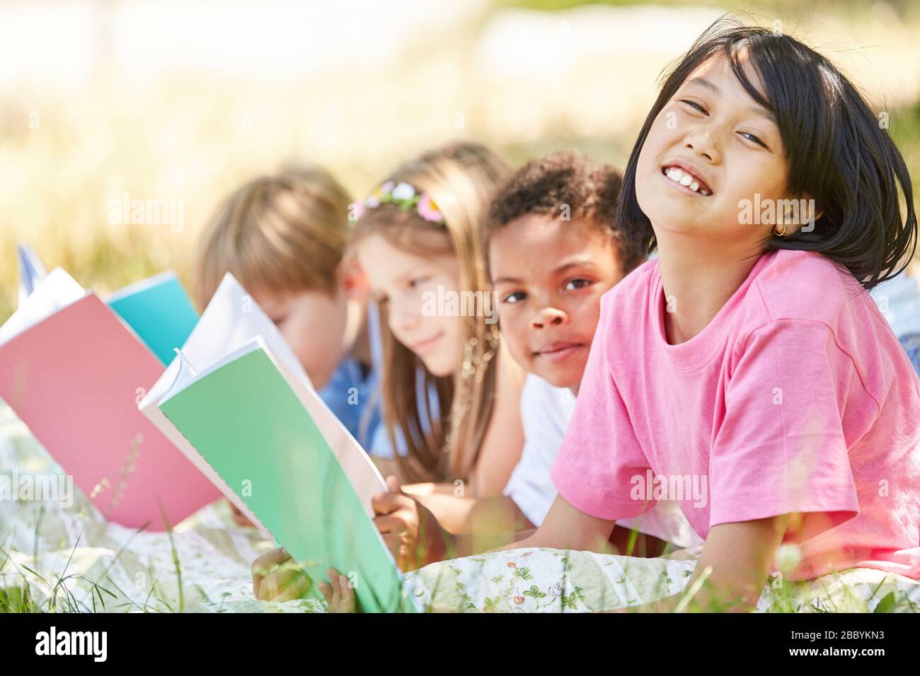 Group of primary school children learning to read outdoors Stock Photo ...