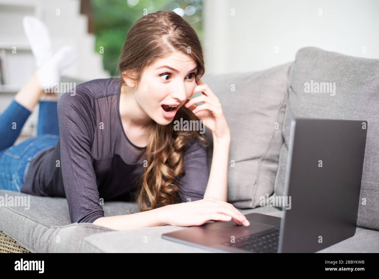Young woman scared in front of laptop at home Stock Photo - Alamy