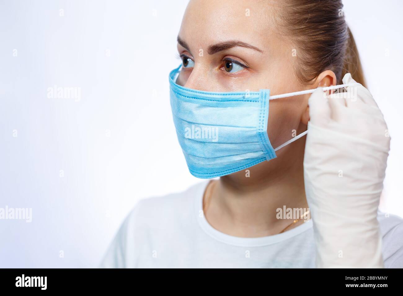 woman health worker demonstrates how to wear a protective medical ...