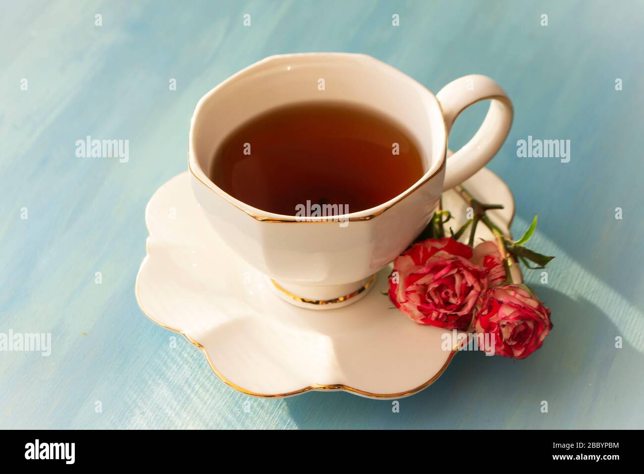 Afternoon tea in white classic with roses on blue wooden background ...