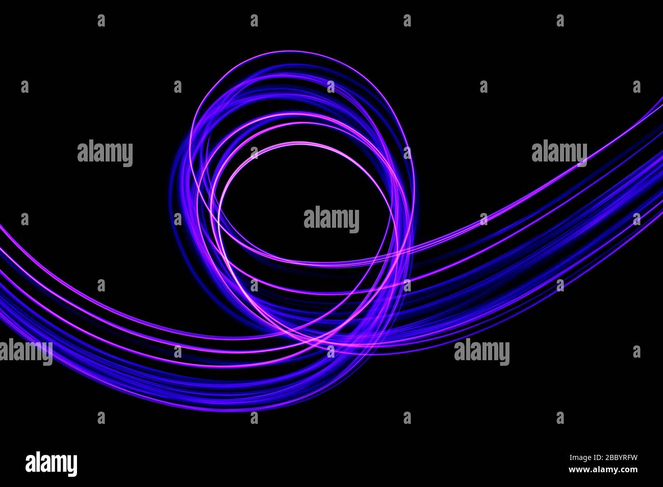 Long exposure photograph of neon purple colour in an abstract swirl ...