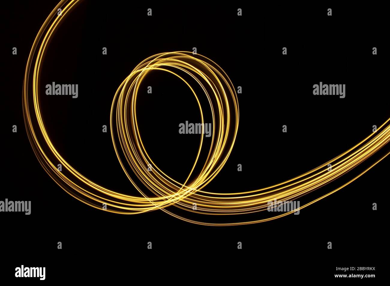 Long exposure photograph of neon gold colour in an abstract swirl ...