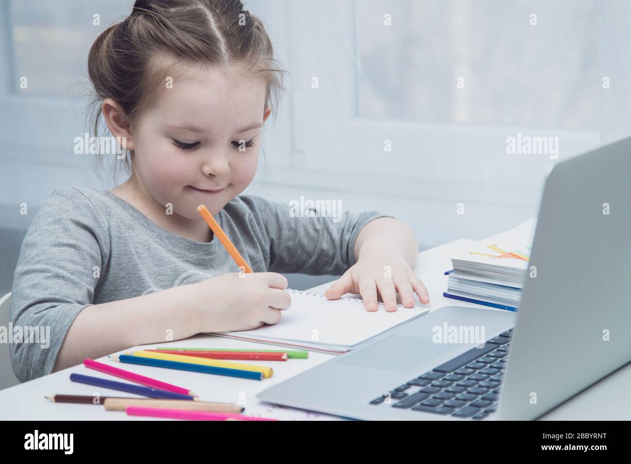 Cute little girl smiling and looking at laptop, Little girl using ...