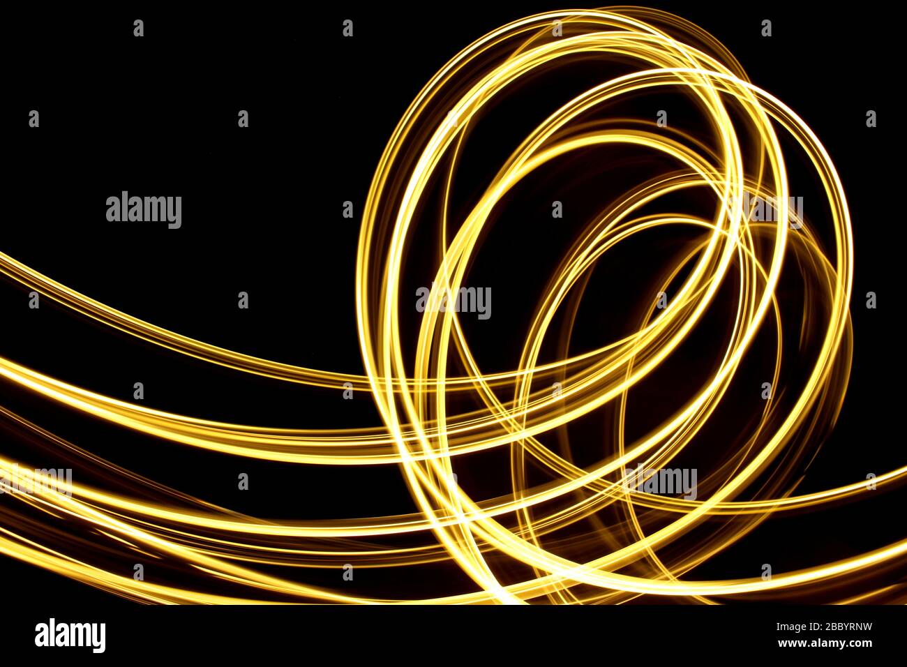 Long exposure photograph of neon gold colour in an abstract swirl ...