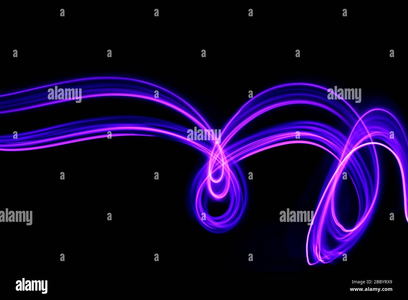Long exposure photograph of neon purple colour in an abstract swirl ...