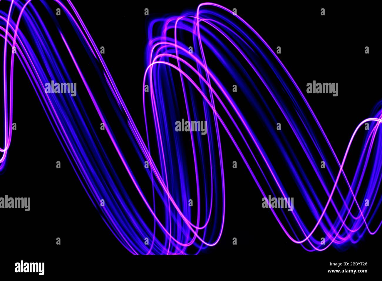 Long exposure photograph of neon purple colour in an abstract swirl ...