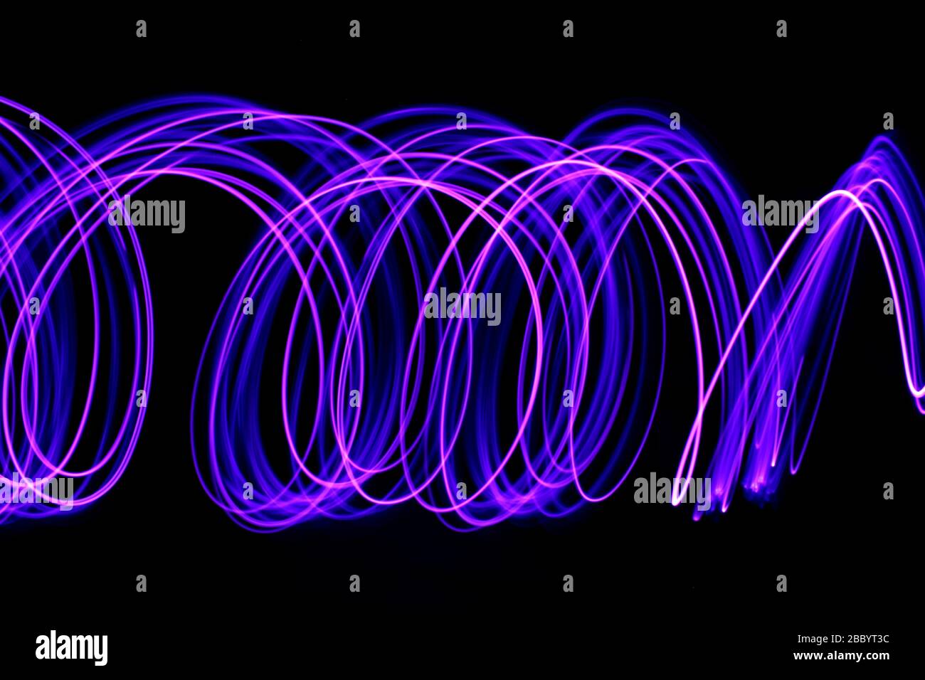 Long exposure photograph of neon purple colour in an abstract swirl ...