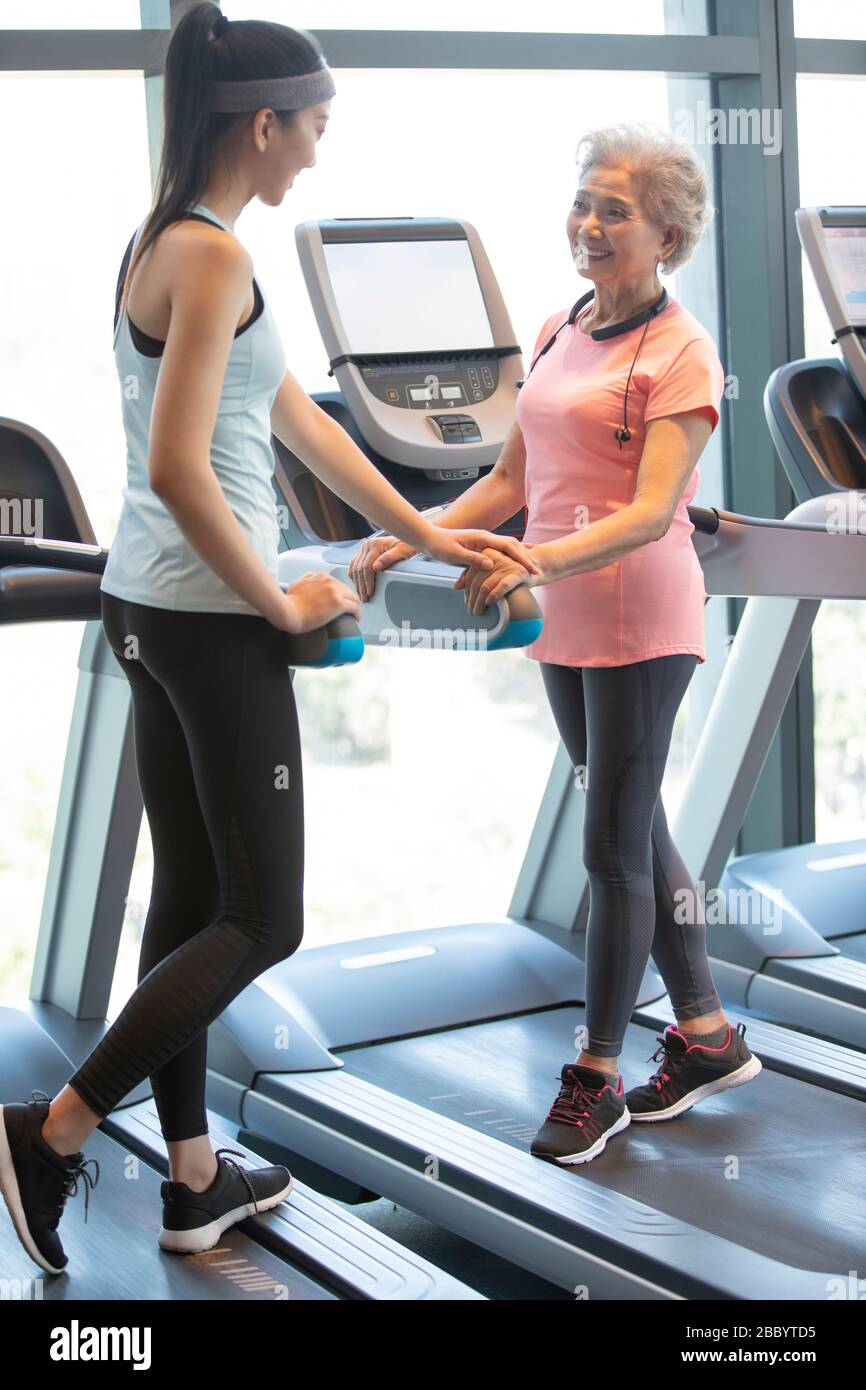 Senior Chinese woman working out with personal trainer at gym Stock ...