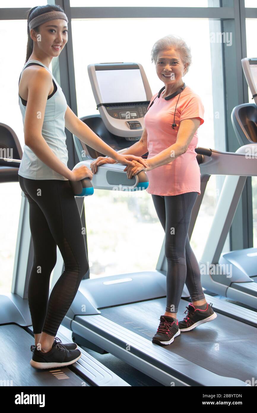 Senior Chinese woman working out with personal trainer at gym Stock ...