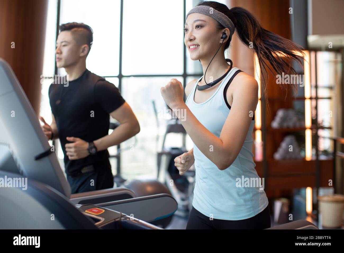 Young Chinese people running on treadmill at gym Stock Photo - Alamy