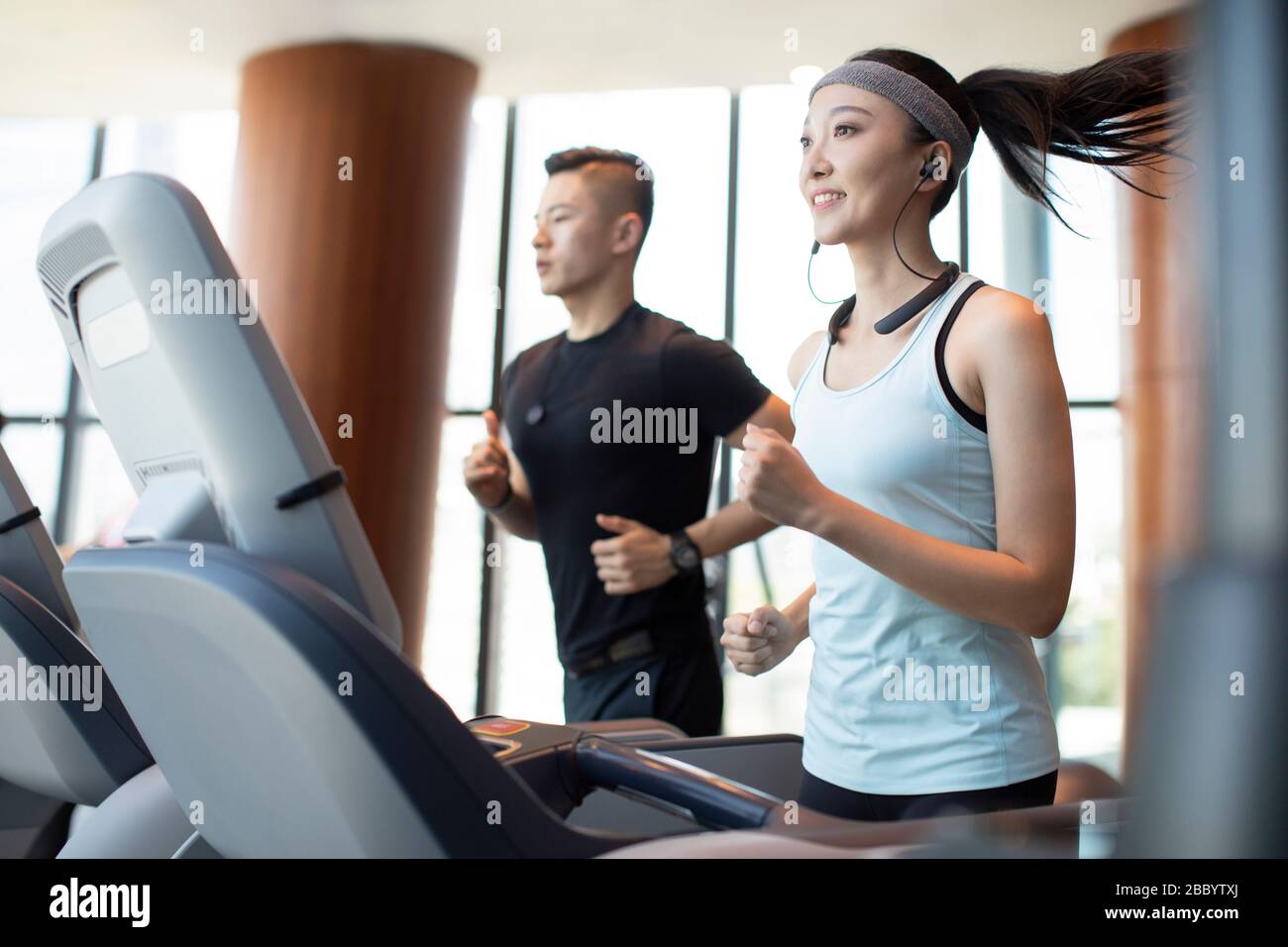 Young Chinese people running on treadmill at gym Stock Photo - Alamy
