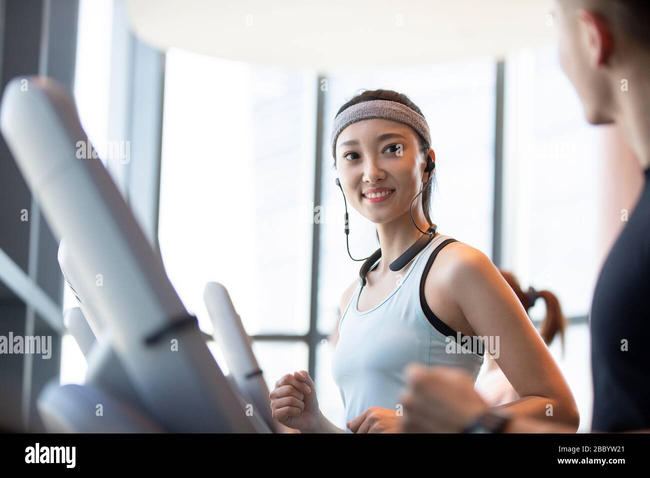 Young Chinese woman working out with personal trainer at gym Stock ...