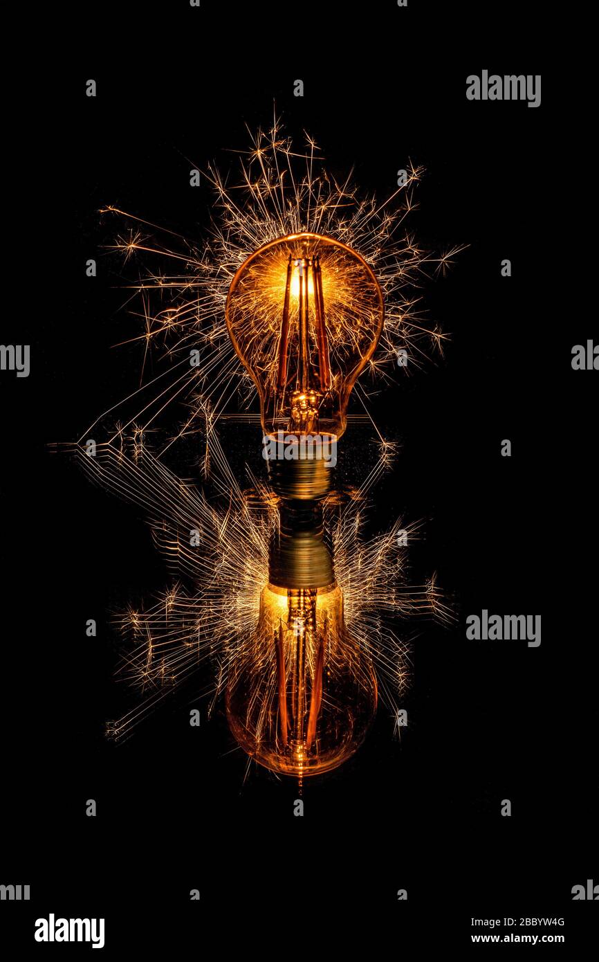 Glowing sparkler behind a retro light bulb Stock Photo - Alamy