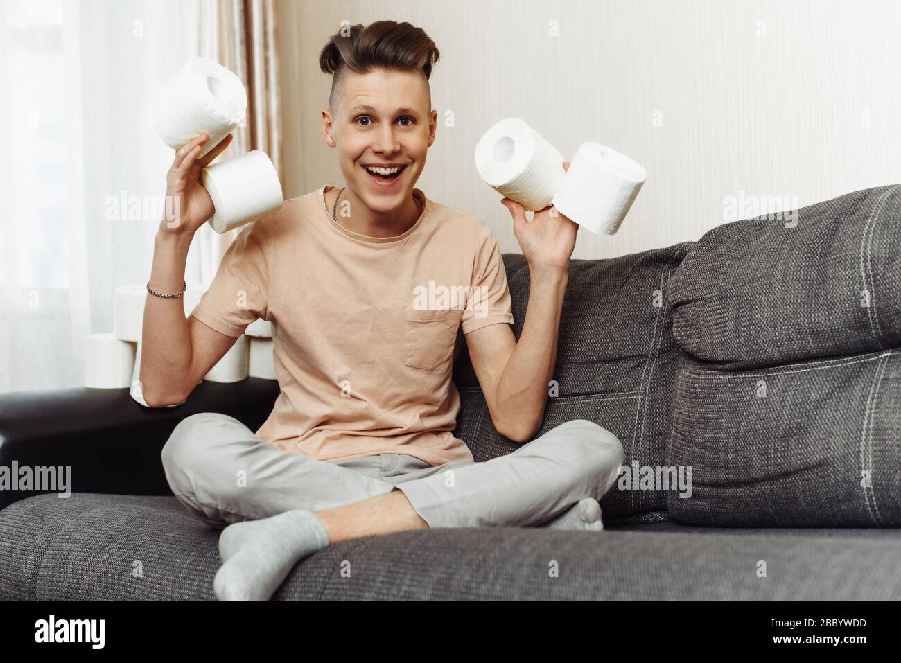 Coronavirus pandemic. Crazy young man surrounded by toilet paper ...