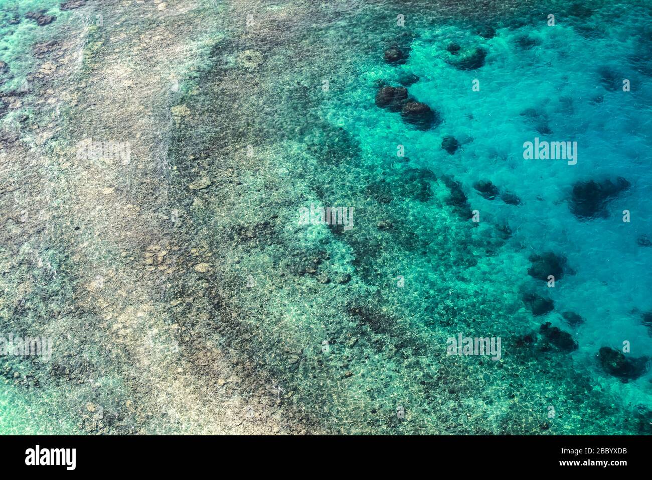 Coastal landscape of Persian Gulf, rocky seabed is under blue shallow ...