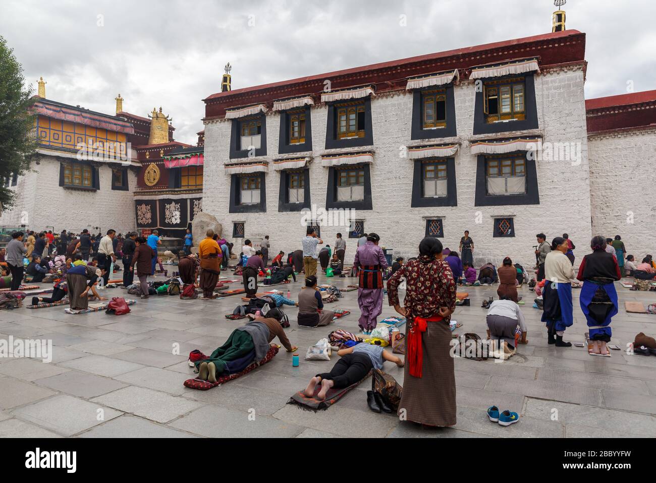 Pilgrims worshipping in front of Jokhang temple. The Buddhist temple in ...