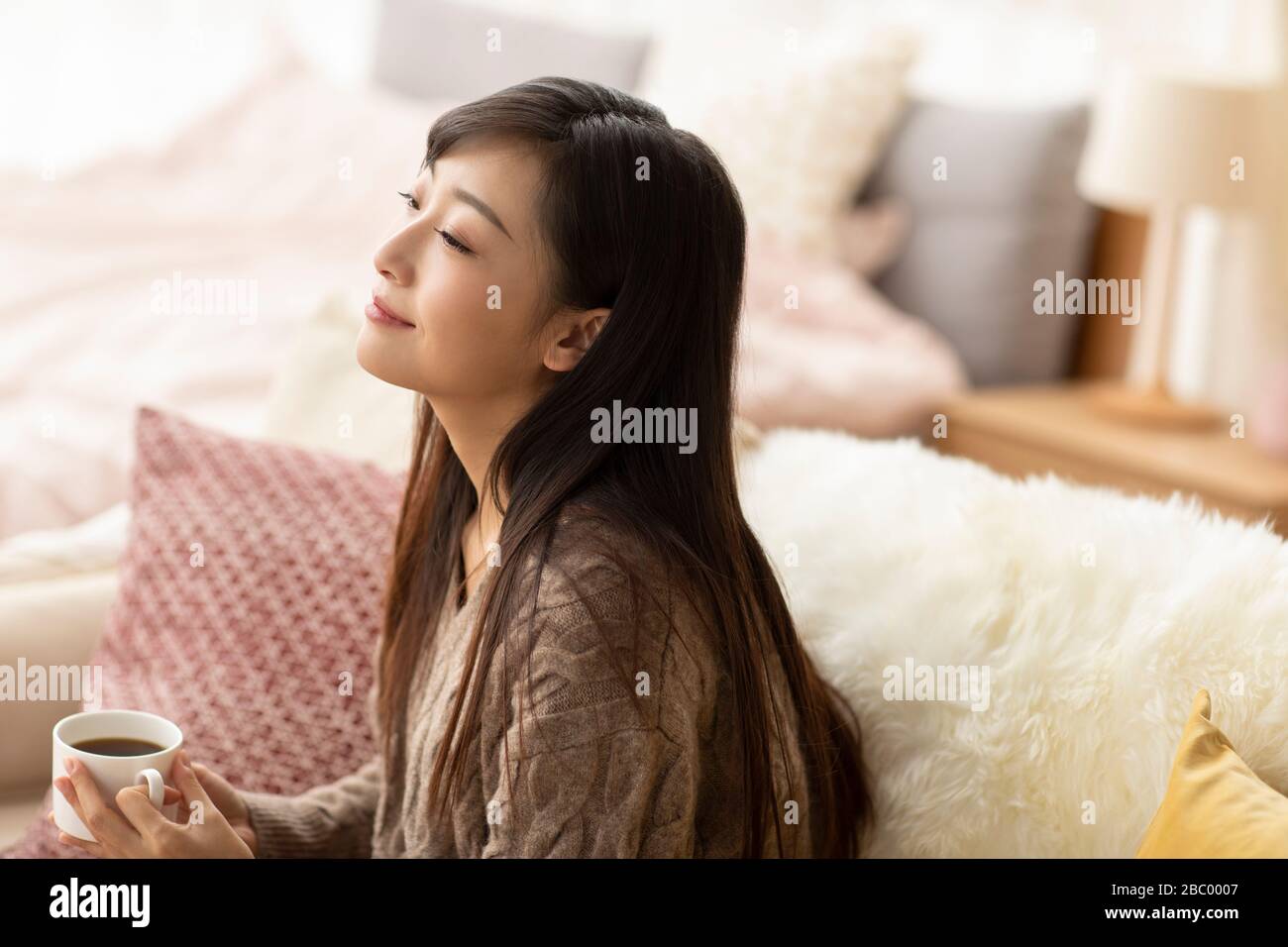 Young woman drinking coffee at home Stock Photo - Alamy