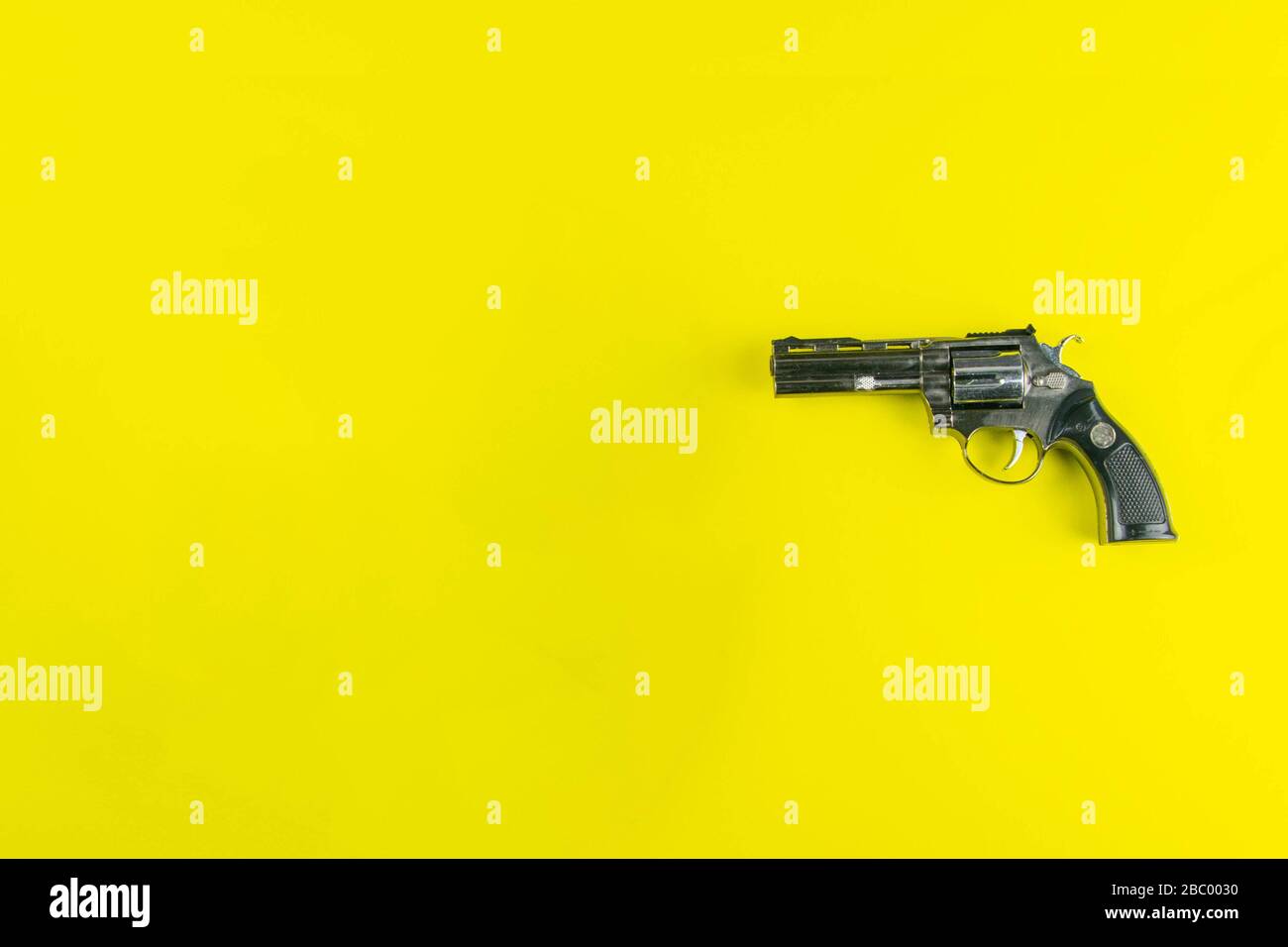 Gun lying on the yellow background. Legalising of weapon. Crime concept ...