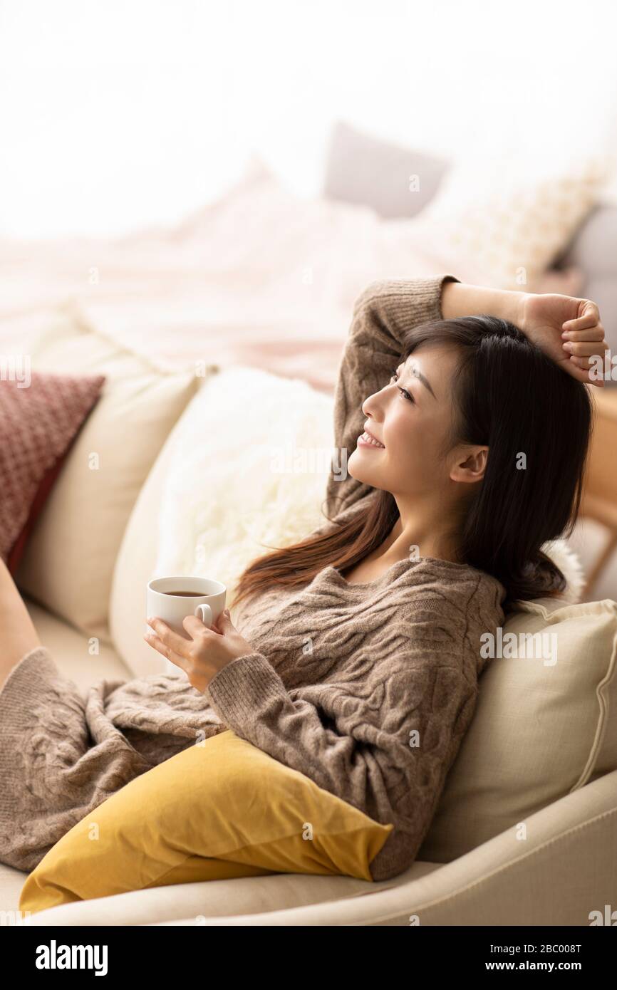 Young woman drinking coffee at home Stock Photo - Alamy