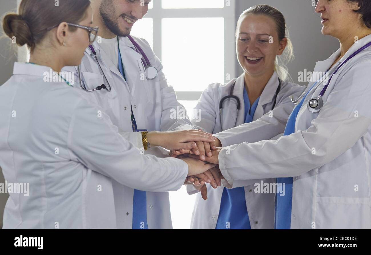 Team of medical workers holding hands together indoors, above view. Unity concept Stock Photo ...