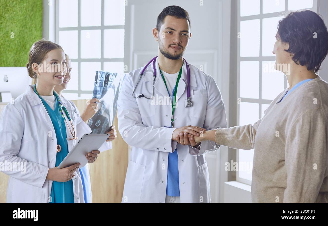 Patient with a group of doctors at the background Stock Photo - Alamy