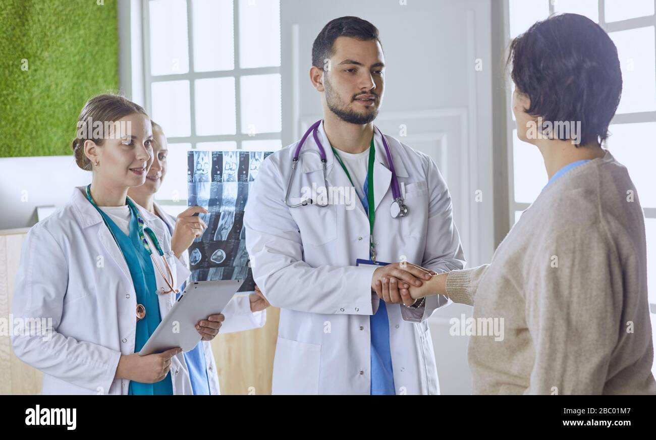 Patient with a group of doctors at the background Stock Photo - Alamy