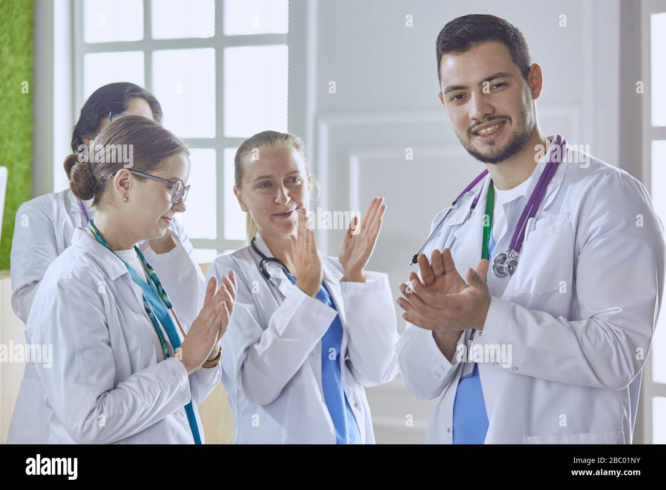 Happy medical team comprising male and female doctors smiling broadly ...