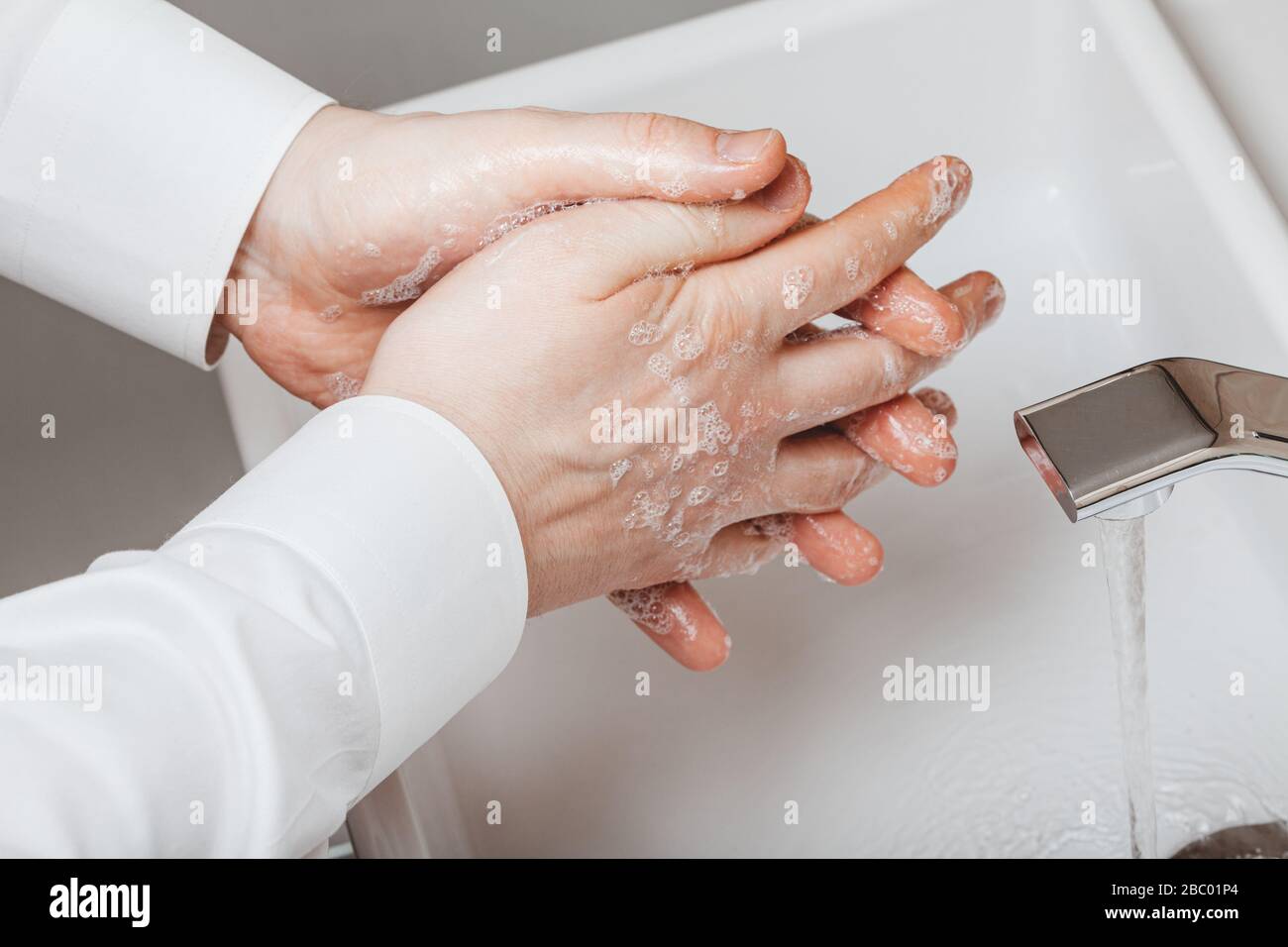 The man washes his hands thoroughly in the home bathroom Stock Photo ...