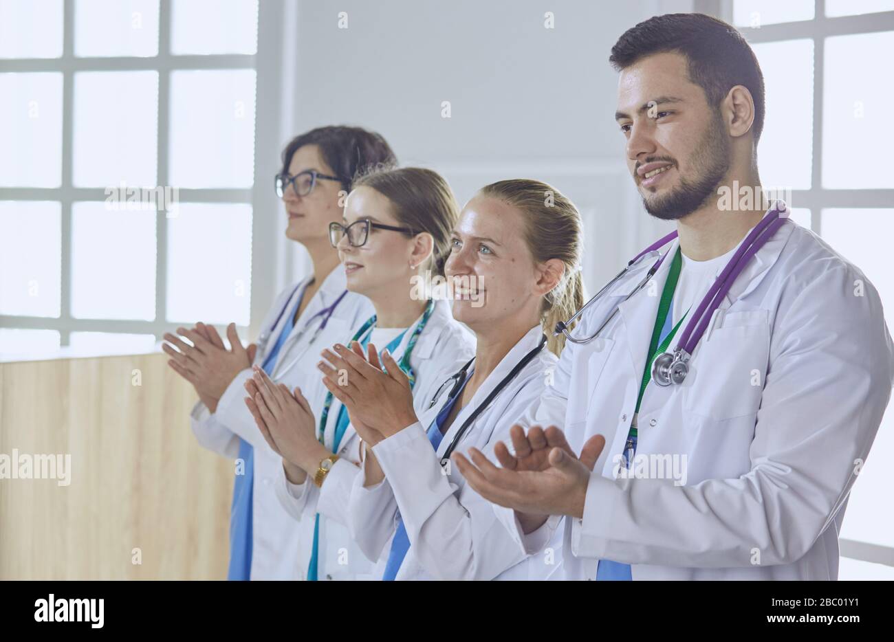 Happy medical team comprising male and female doctors smiling broadly ...