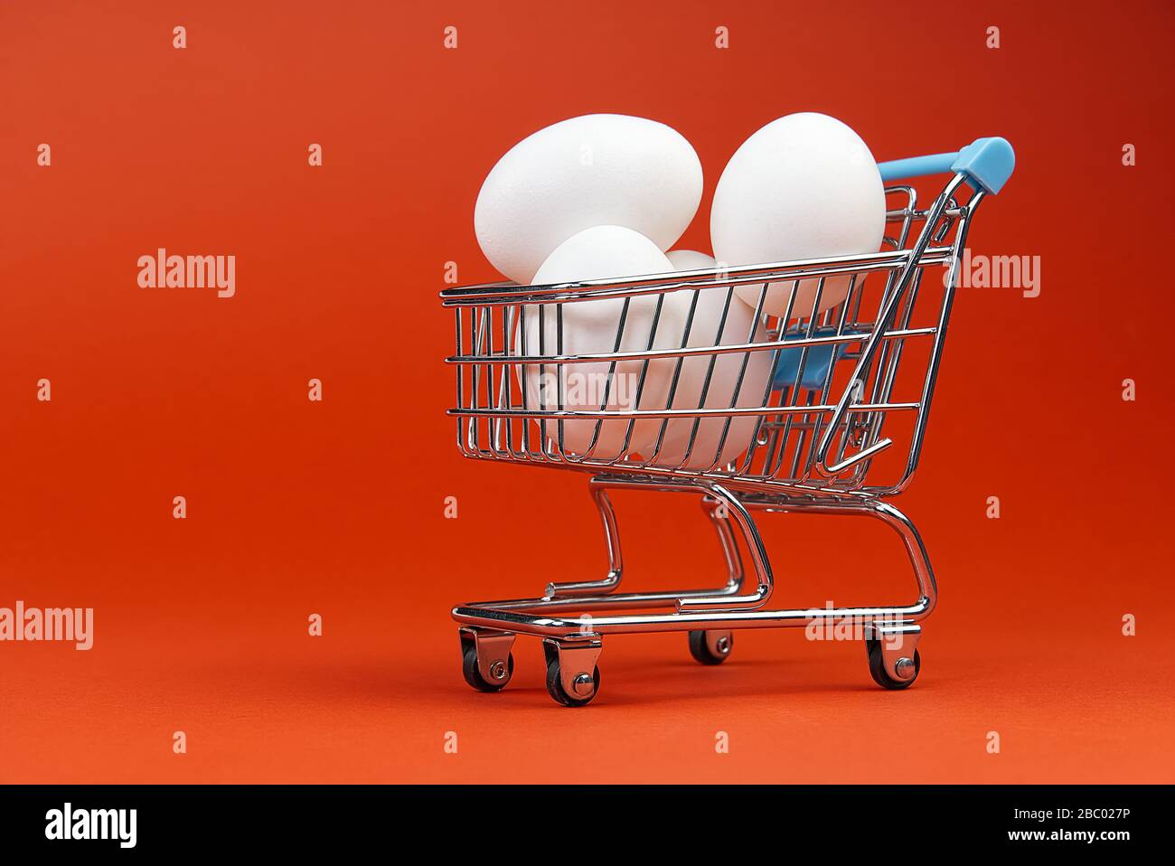 chicken white eggs in a shopping cart. isolated on orange Stock Photo ...
