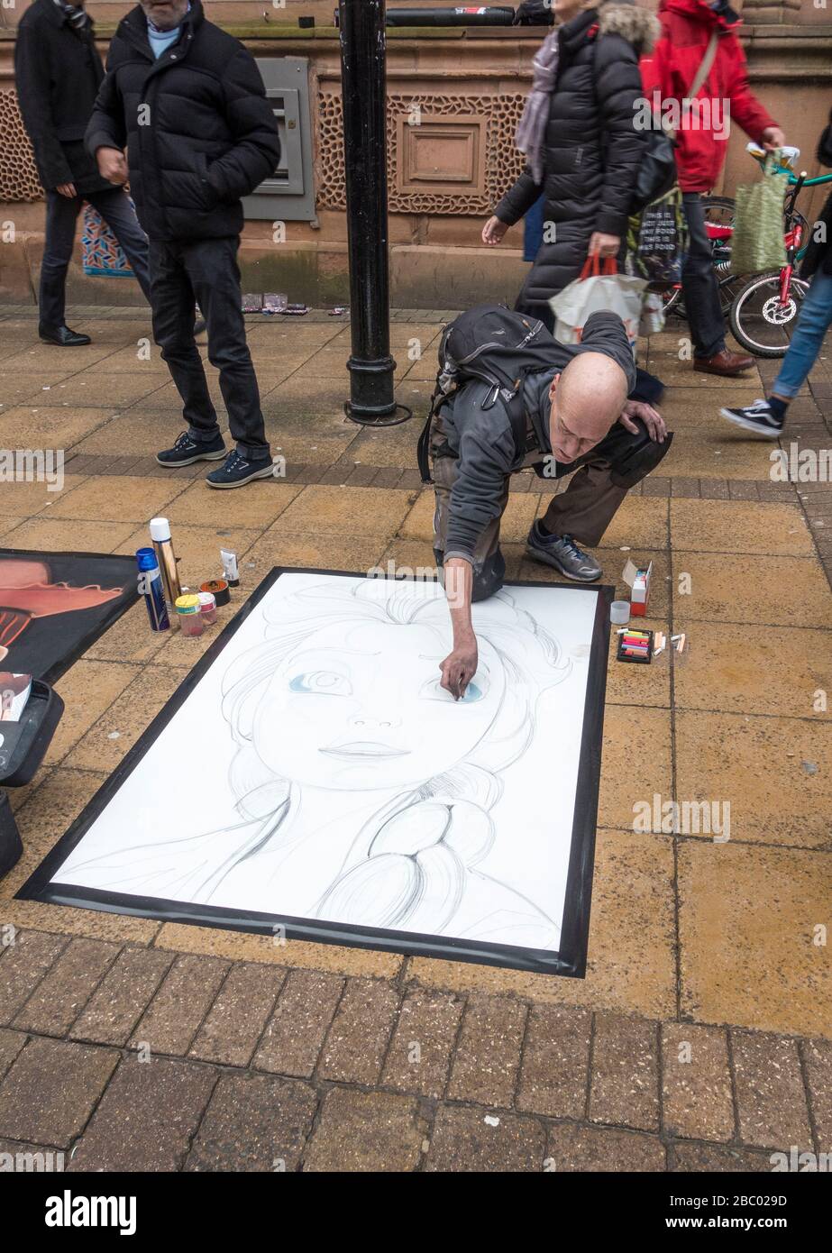 Pavement artist working on picture on board High Street Lincoln 2019 ...