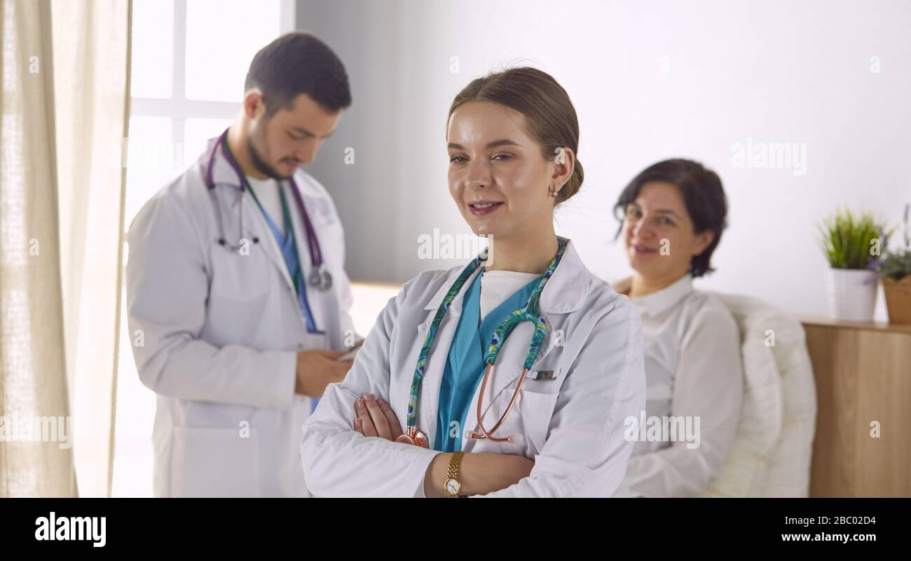 Patient with a group of doctors at the background Stock Photo - Alamy