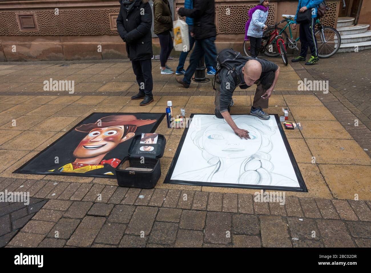Pavement artist working on picture on board High Street Lincoln 2019 ...