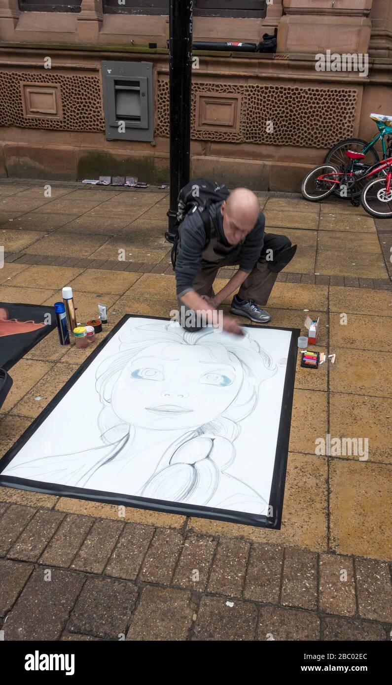 Pavement artist working on picture on board High Street Lincoln 2019 ...