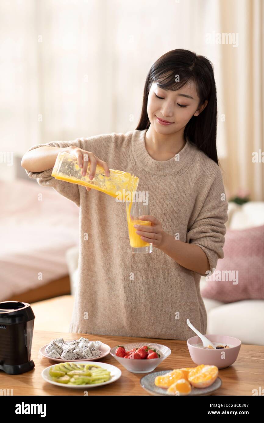 Young Chinese woman making juice at home Stock Photo - Alamy