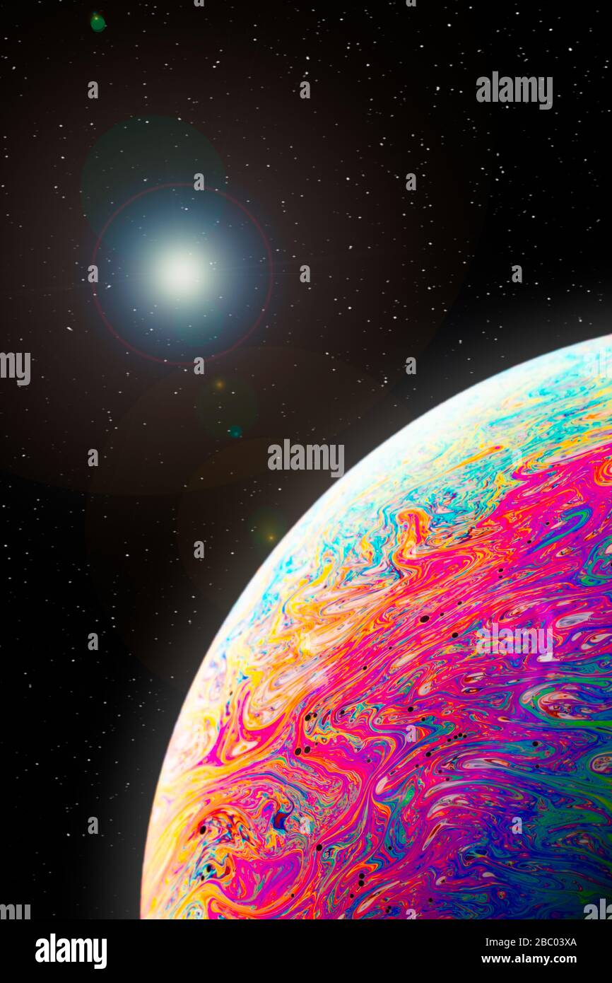 Macrophotograph of a colorful soap bubble looking like a planet with a ...