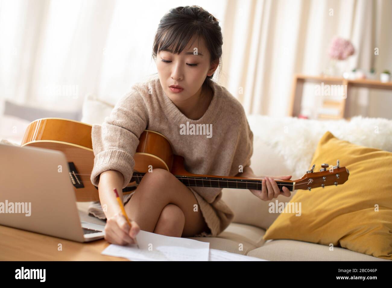 Young Chinese woman writing music at home Stock Photo - Alamy