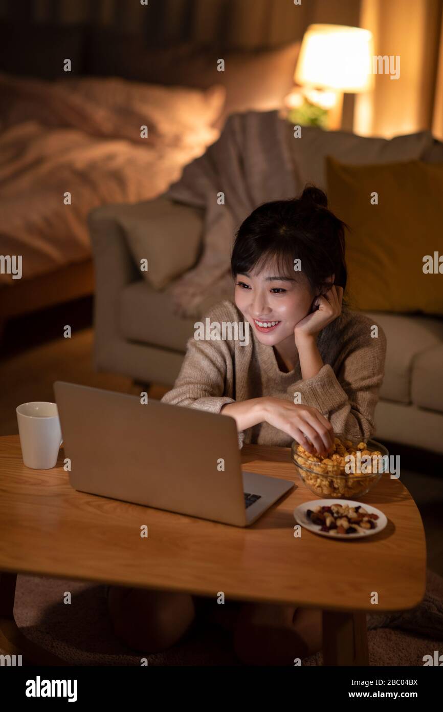 Young Chinese woman watching movie on laptop Stock Photo - Alamy